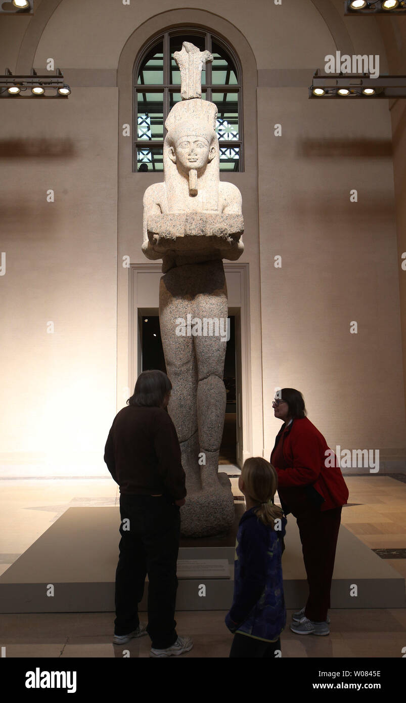 A family stops to look at the Colossal Statue of the god Hapy, made ...