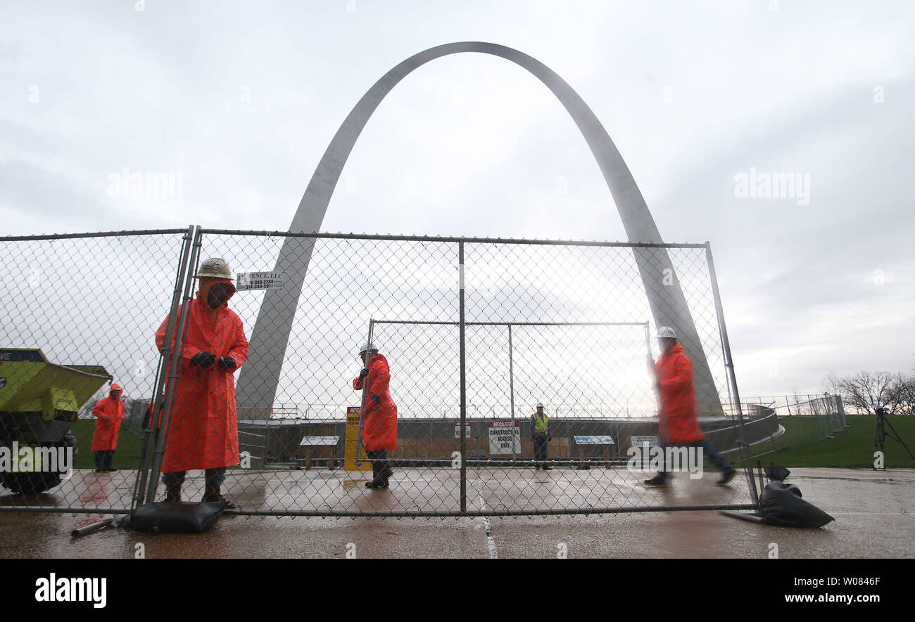 Construction workers remove sections of fencing around the Gateway Arch ...