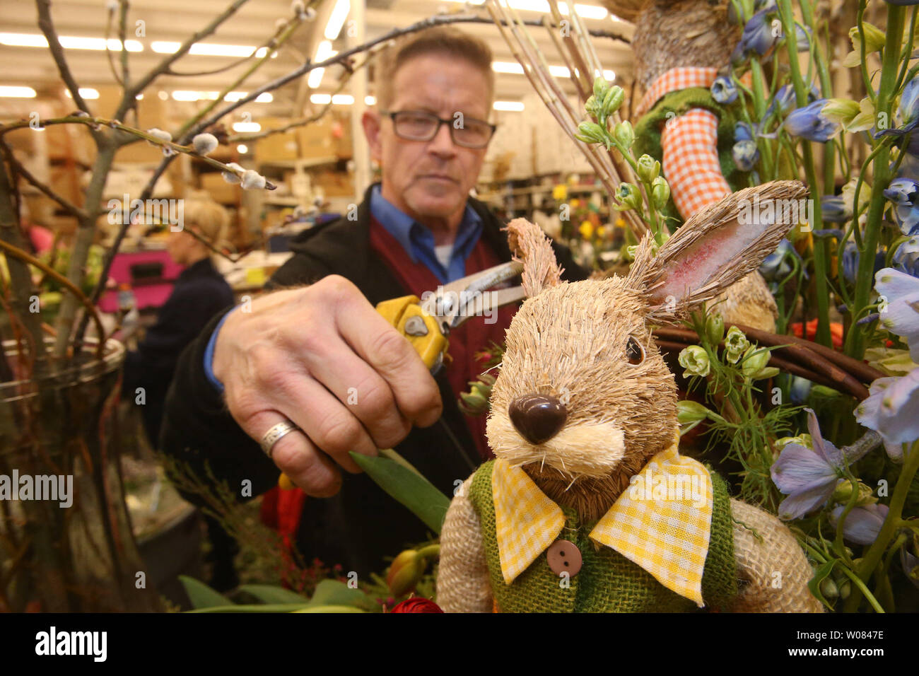 Master floral arranger Scott Hepper puts the finishing touches on a ...
