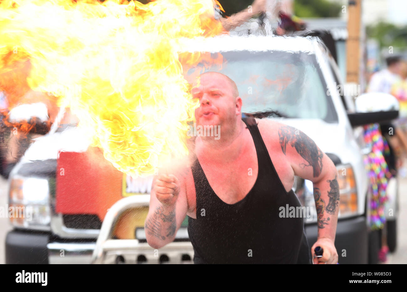 A parade participant blows fire while marching in the St. Louis ...