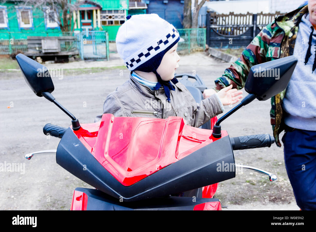 pictured in the photo a little boy is sitting on a red motorcycle Stock ...