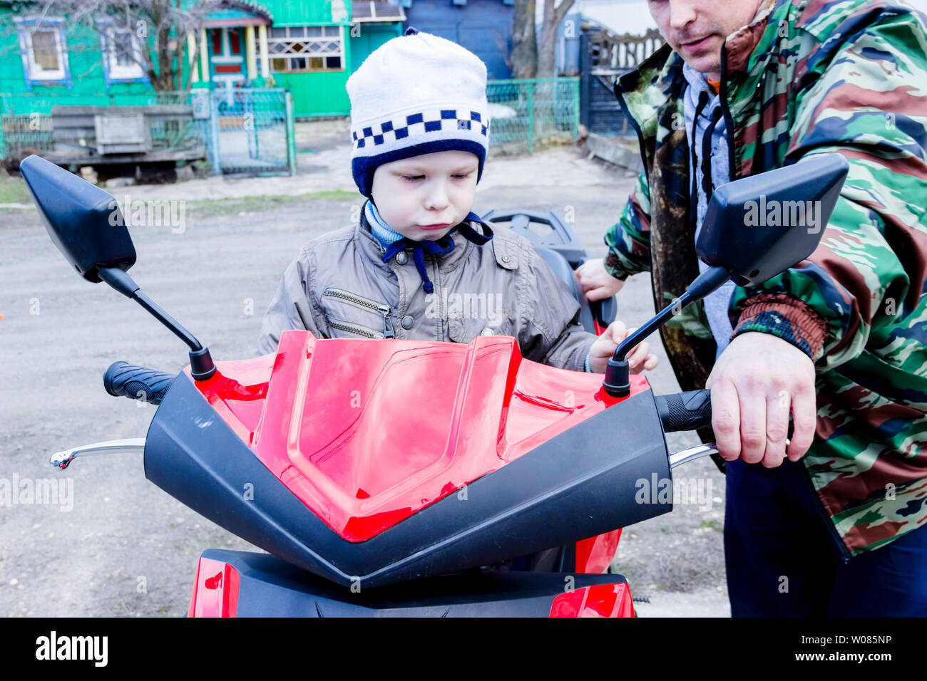pictured in the photo a little boy is sitting on a red motorcycle Stock ...