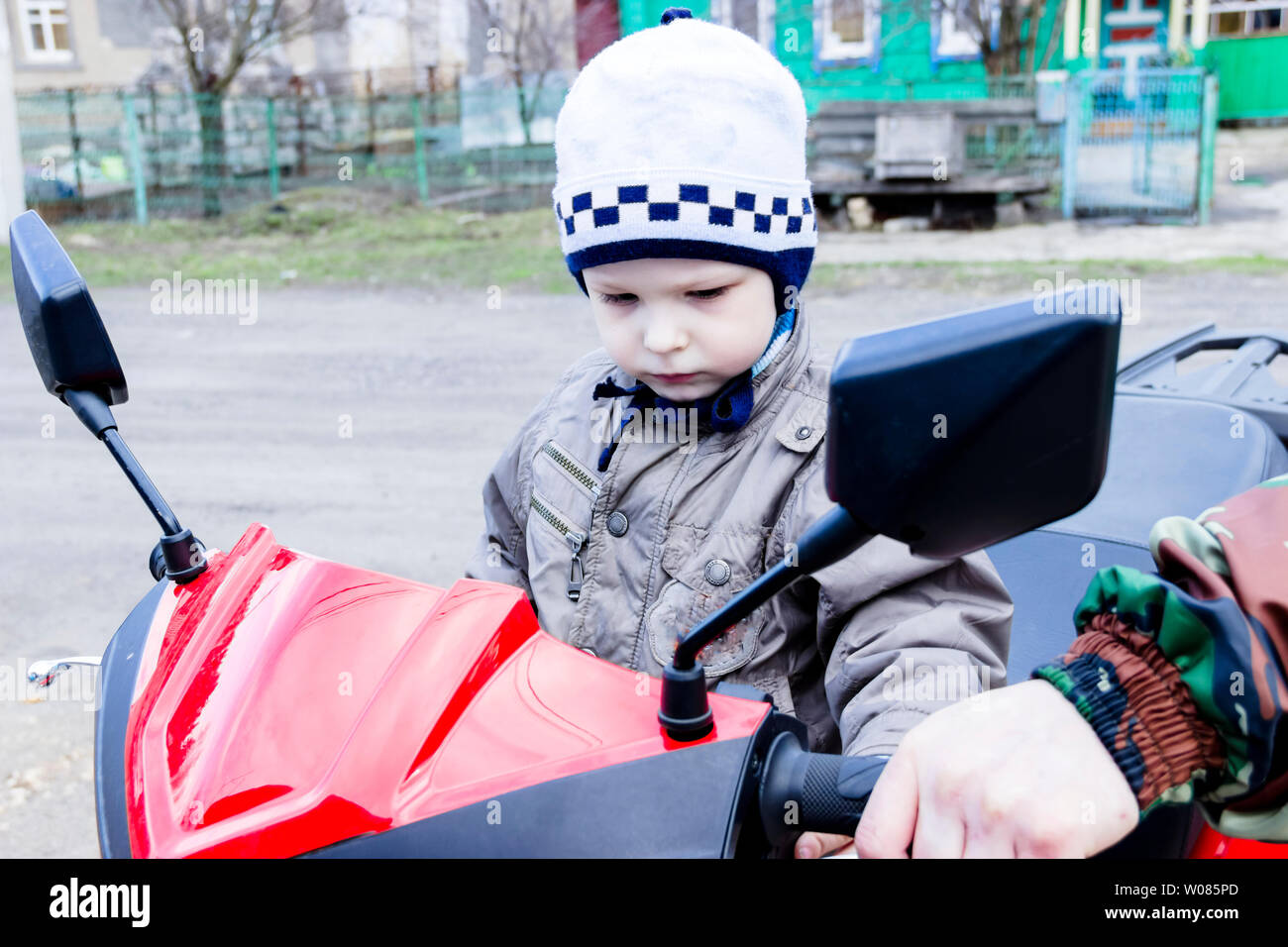 pictured in the photo a little boy is sitting on a red motorcycle Stock ...