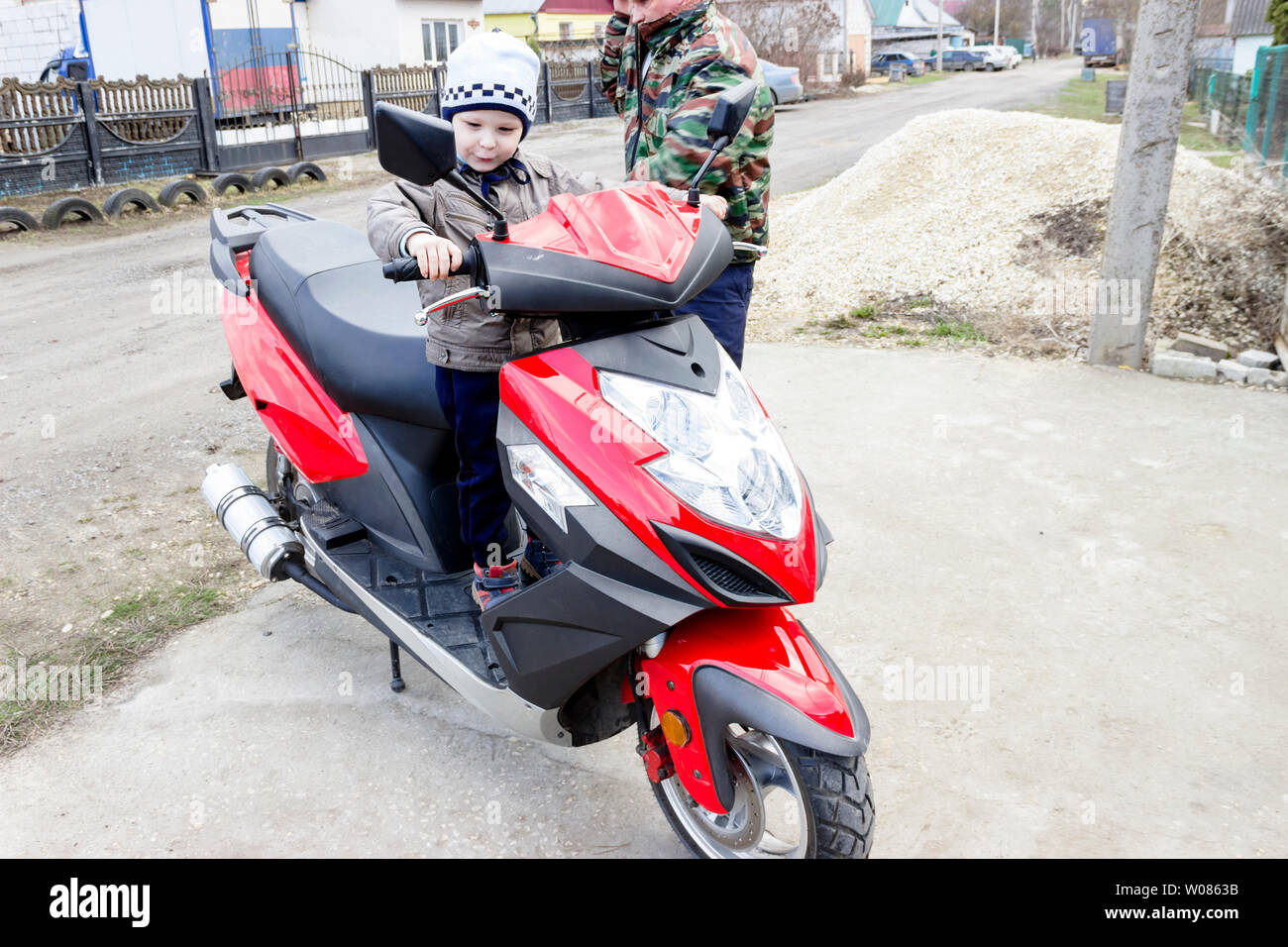 pictured in the photo a little boy is sitting on a red motorcycle Stock ...