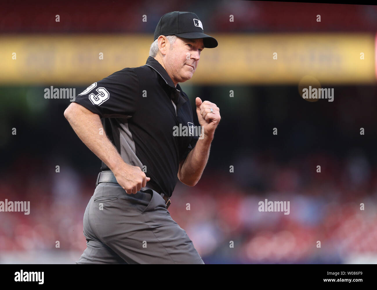 Major League umpire crew chief Mike Winters runs to first base for the ...