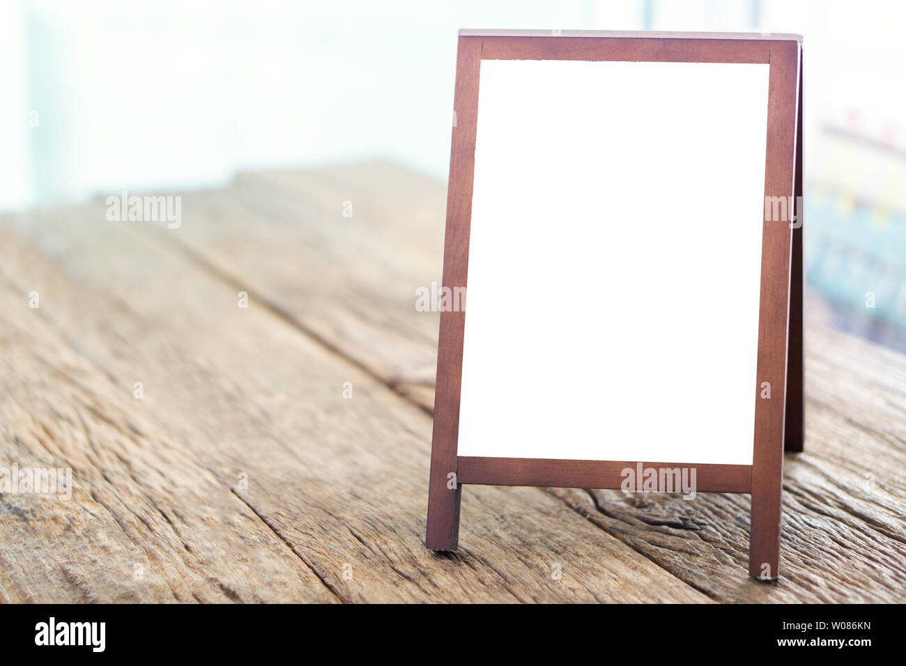 Mock up blank advertising whiteboard with easel standing on wood table ...