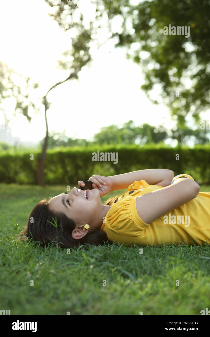 Indian girl talking on a mobile phone in a lawn Stock Photo - Alamy