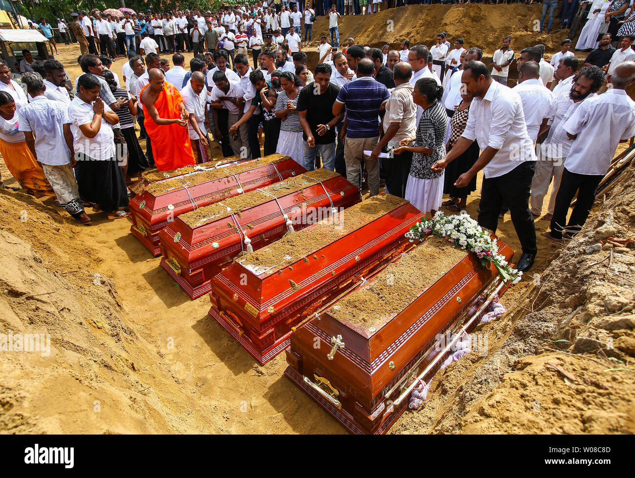 Sri Lankans prepare to bury the coffins carrying remains of victims ...