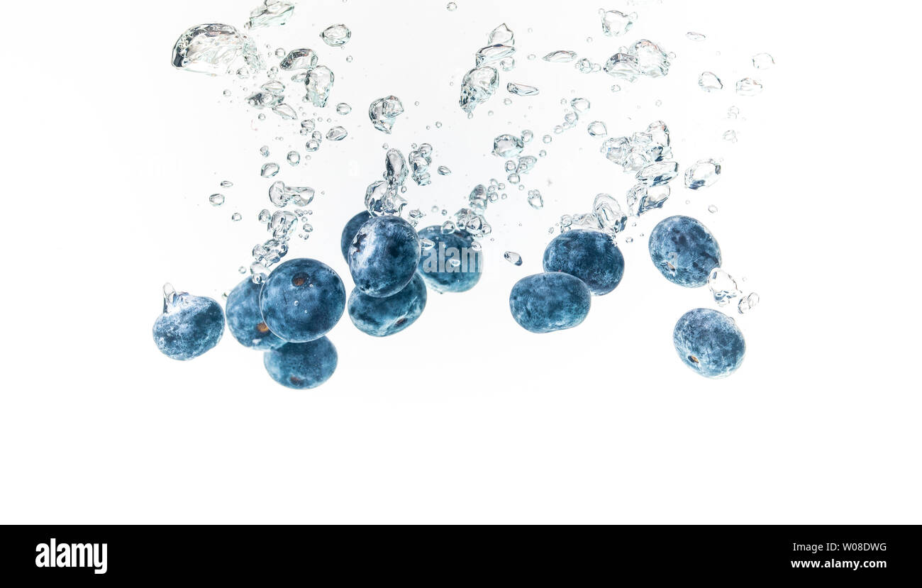 Blueberry’s splashing into crystal clear water with air bubbles Stock ...