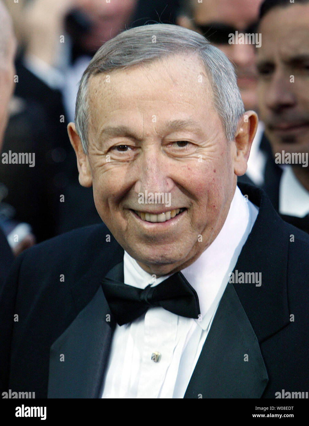 Roy Disney smiles as he faces photographers on the red carpet at the ...