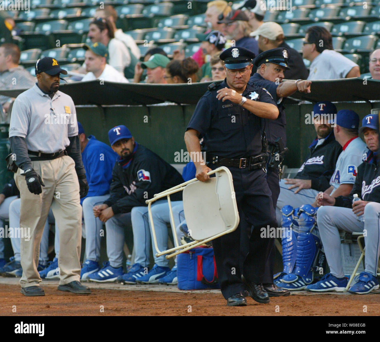 An Oakland Police officer removes an extra chair by the Texas Rangers ...