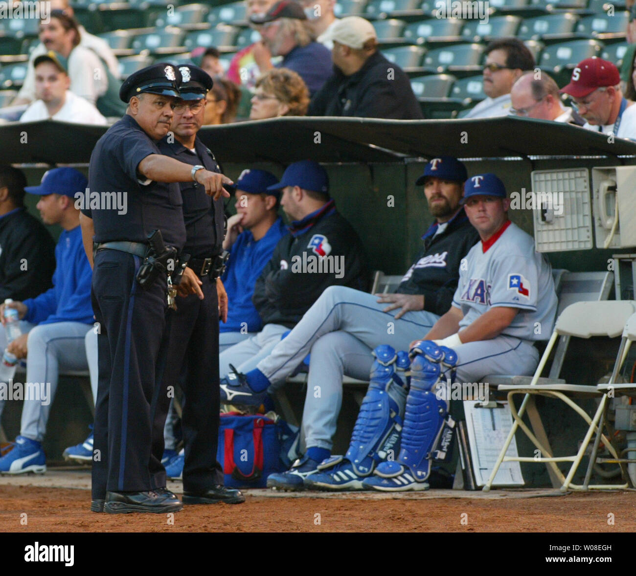 Oakland Police officers stand guard by the Texas Rangers bullpen before ...