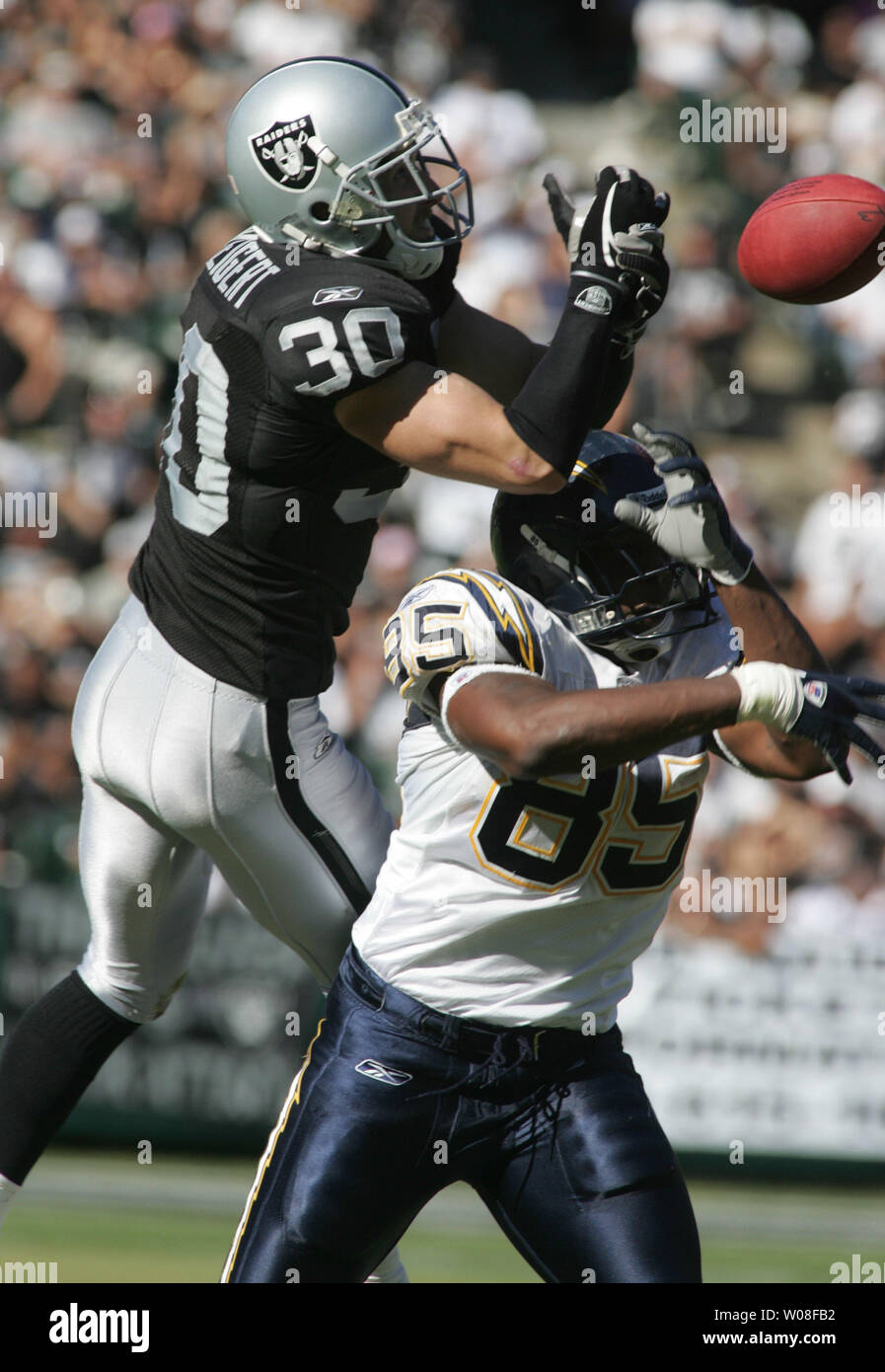 Oakland Raiders Stuart Schweigert (30) goes over the back of San Diego ...