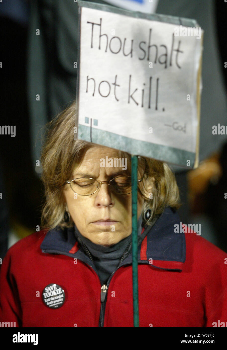 A woman prays outside San Quentin Prison where Stanley "Tookie ...