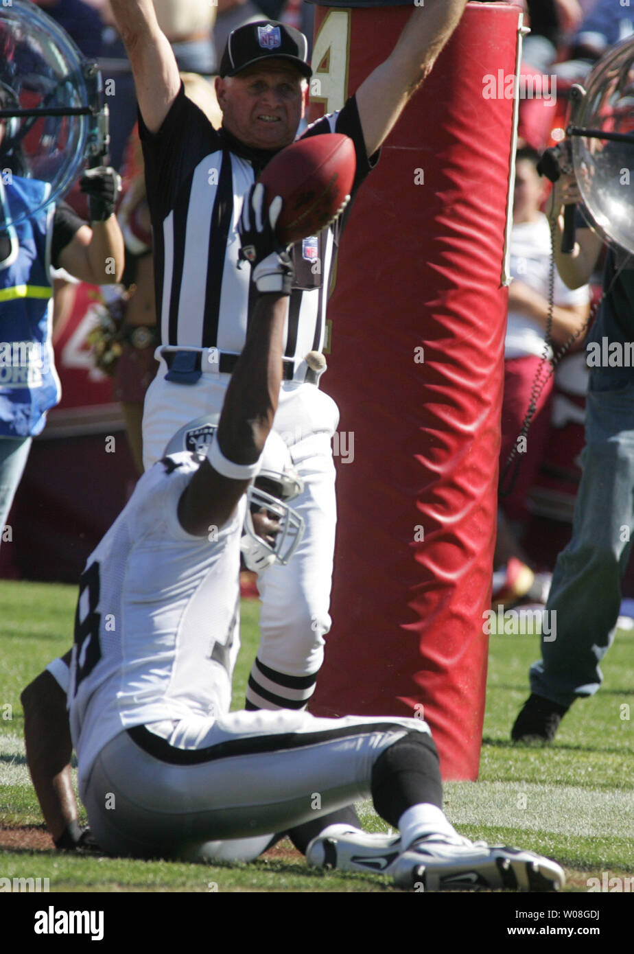 Oakland Raiders Randy Moss holds up the football as back judge Don ...