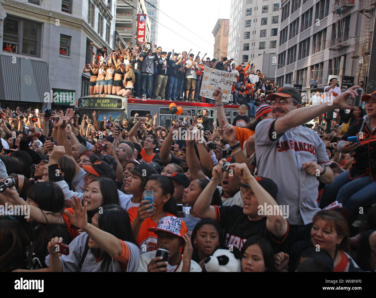 Frenzied Giants fans cover the top of a Muni bus stuck in the crowd as ...