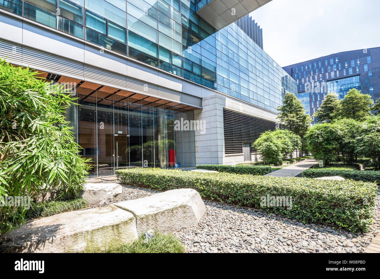 Modern building and green footpath Stock Photo - Alamy