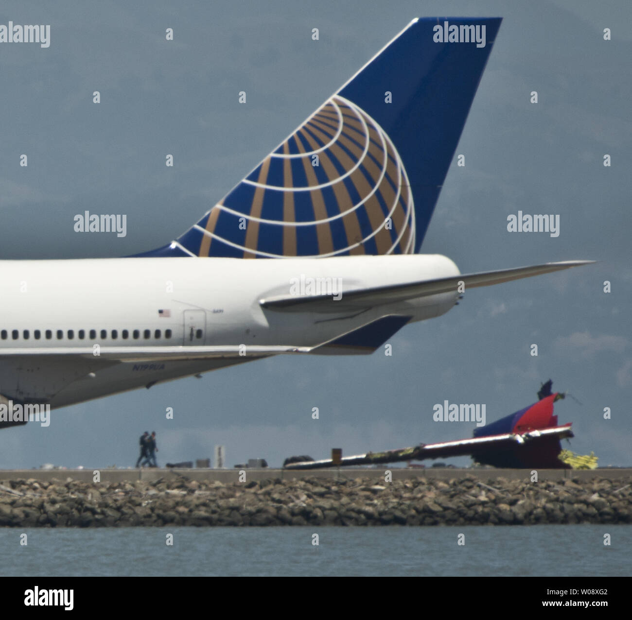 A United plane is towed by the tail section of an Asiana Air Boeing 777 ...