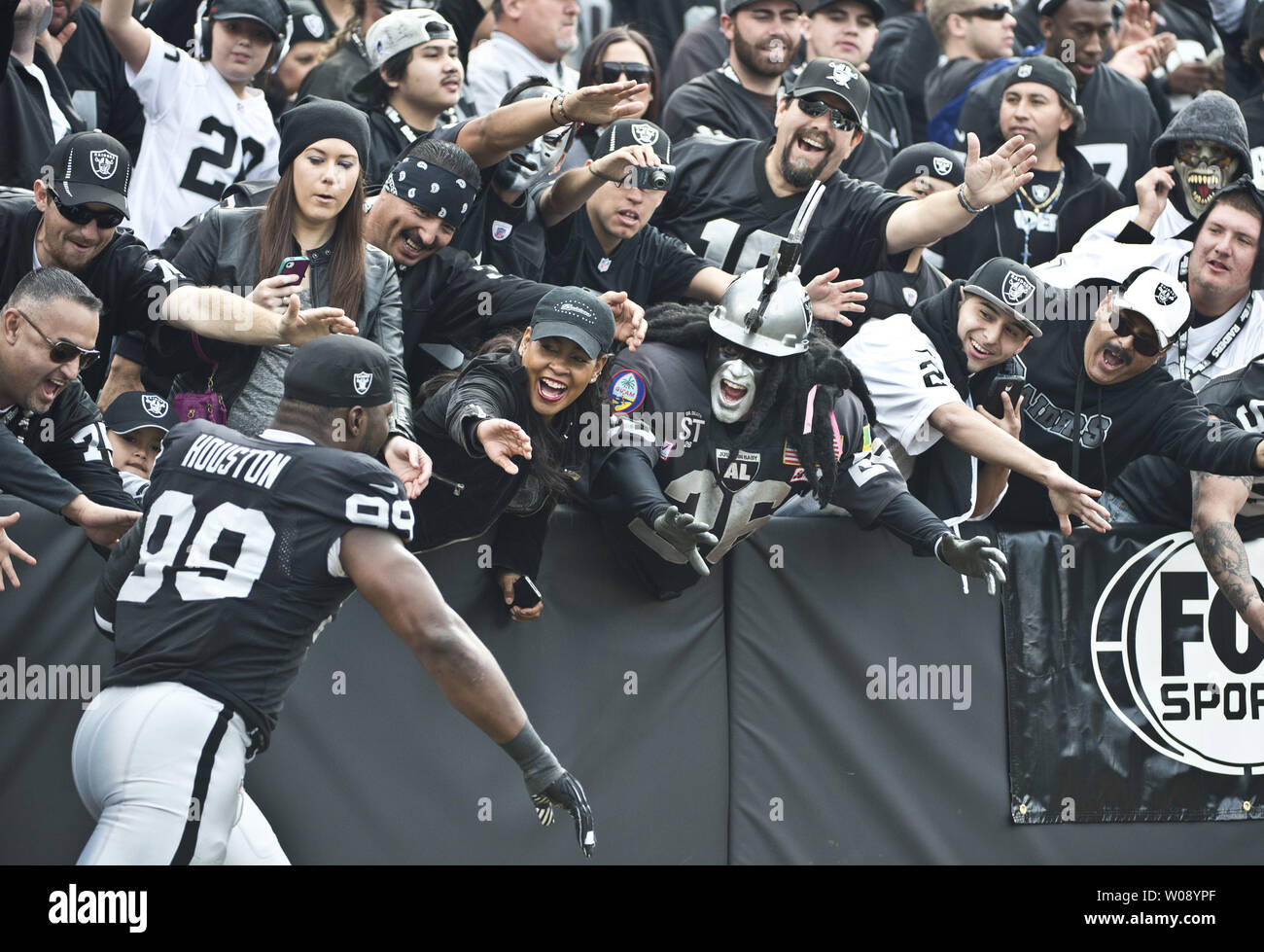 Oakland Raiders Lamarr Houston (99) greets fans in the Black Hole ...
