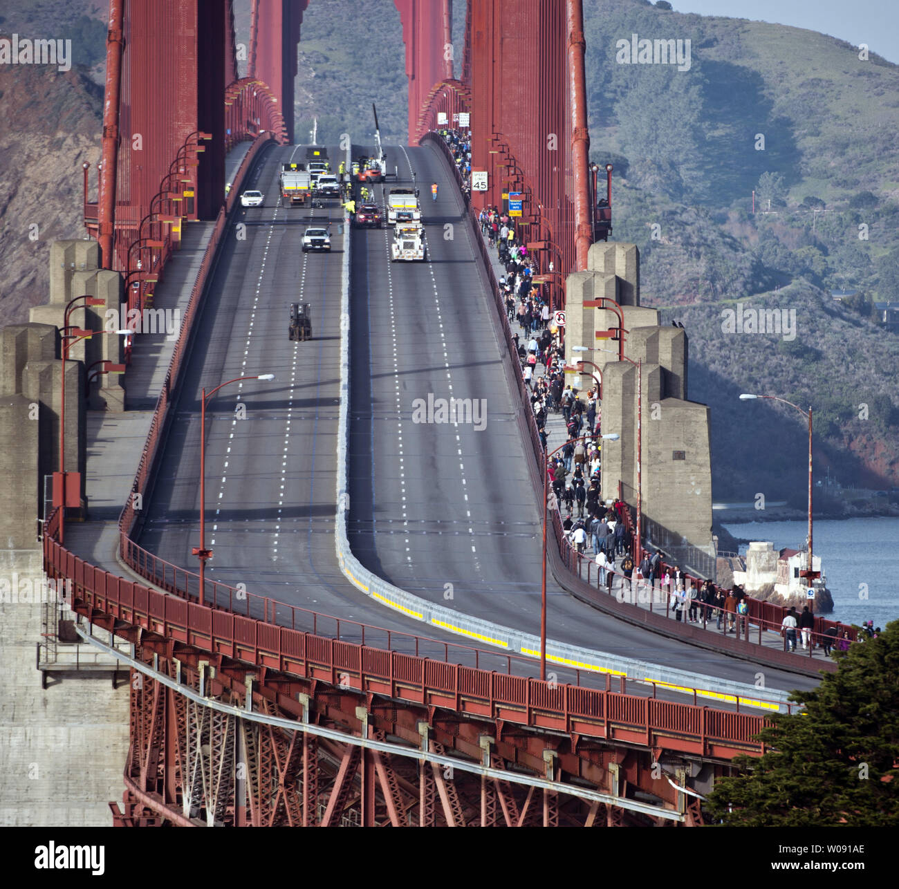 Workers install a movable median barrier on the Golden Gate Bridge in ...