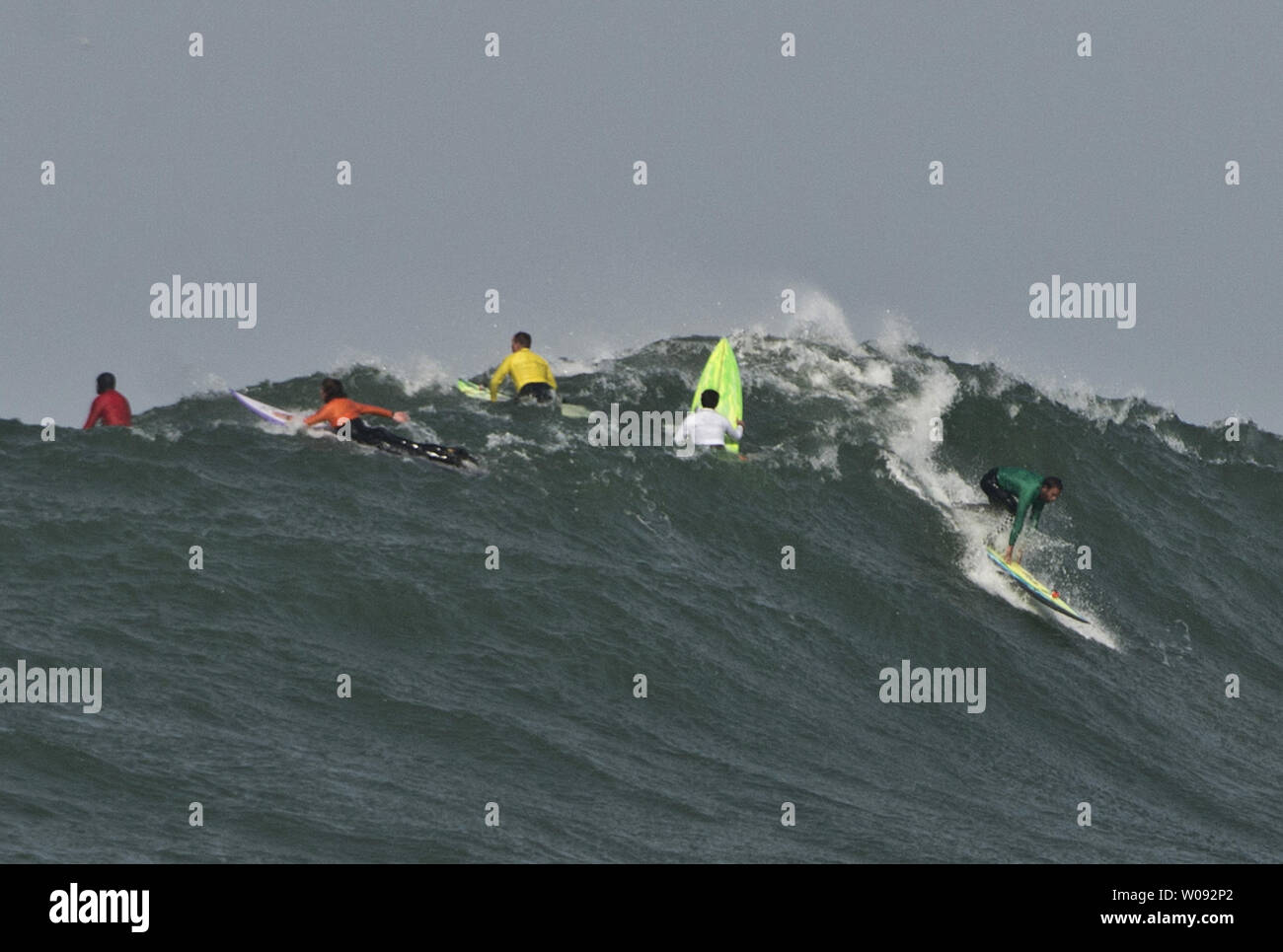 Nathan Fletcher (green) catches a wave as fellow competitors look for ...