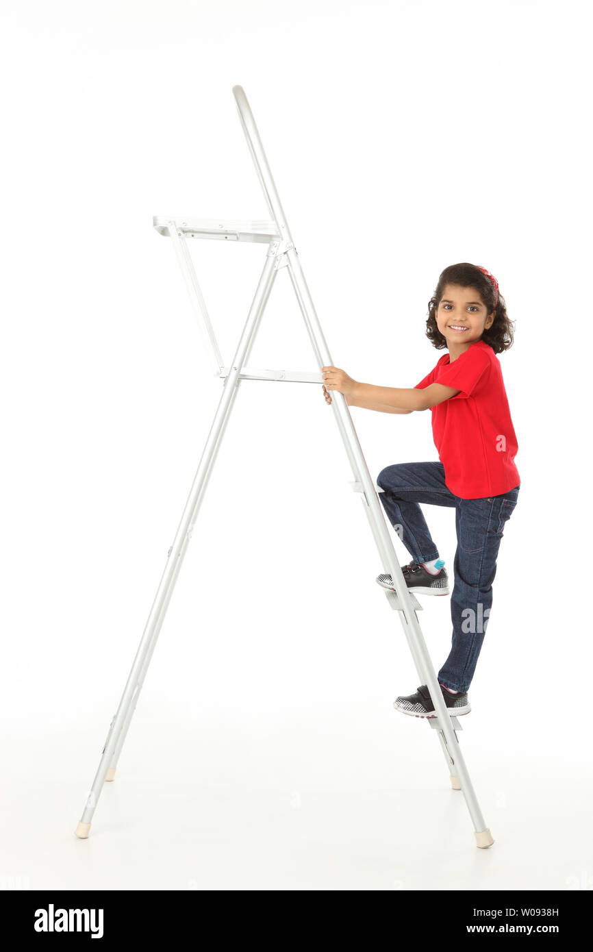 Girl climbing on a step ladder and smiling Stock Photo - Alamy