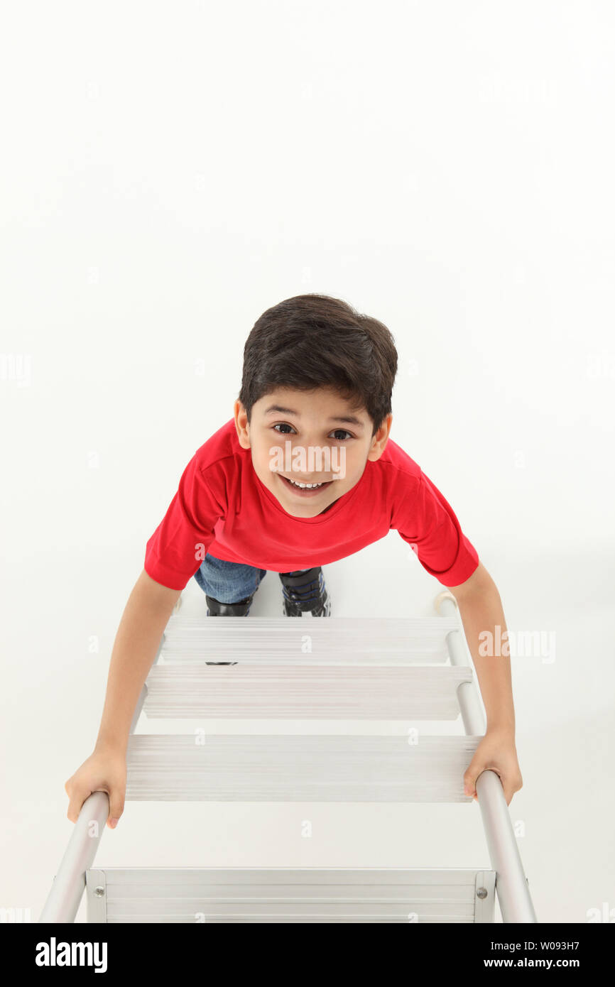 Indian boy climbing on a step ladder and smiling Stock Photo - Alamy