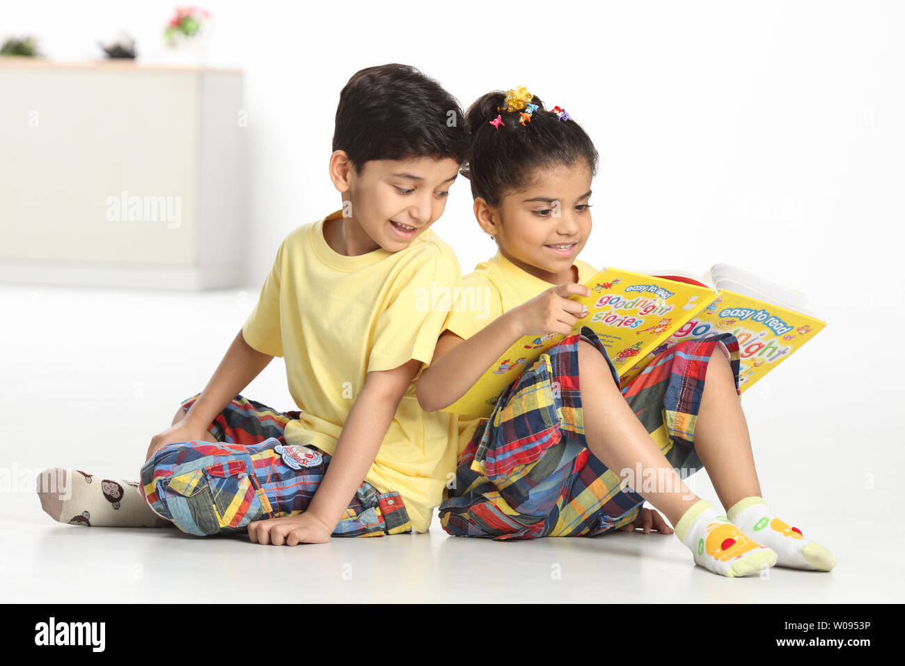 Two children reading a book Stock Photo - Alamy