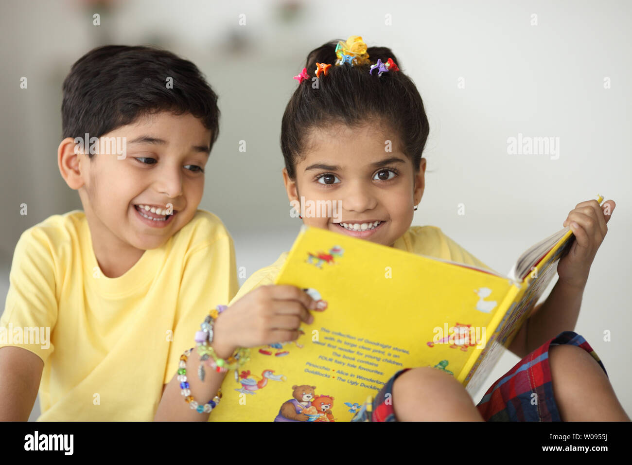 Two Indian children reading a book Stock Photo - Alamy