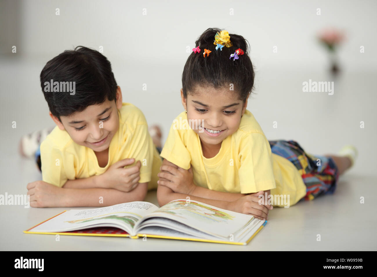 Two Indian children reading a book Stock Photo - Alamy