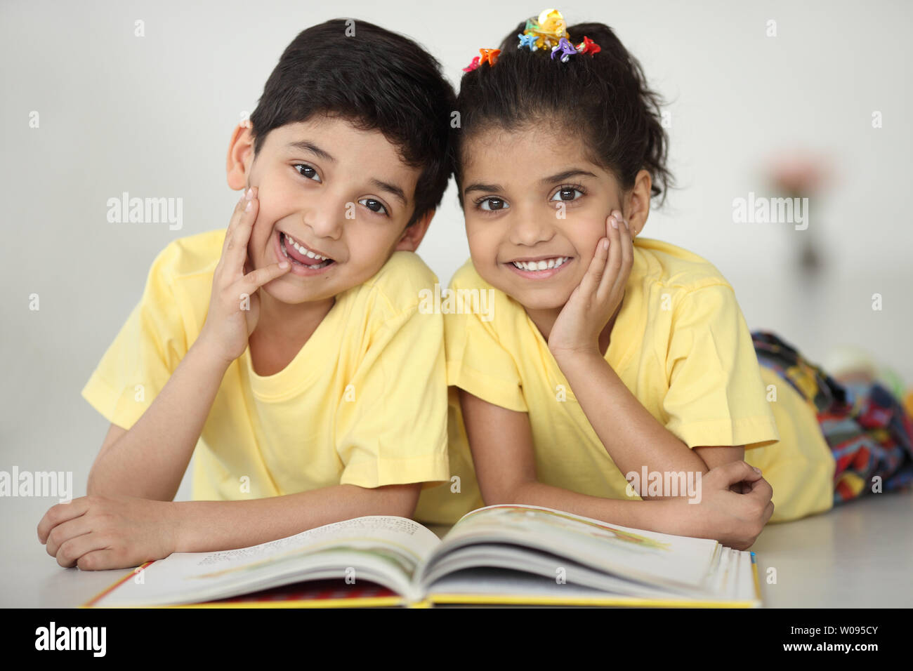 Two children reading a book Stock Photo - Alamy