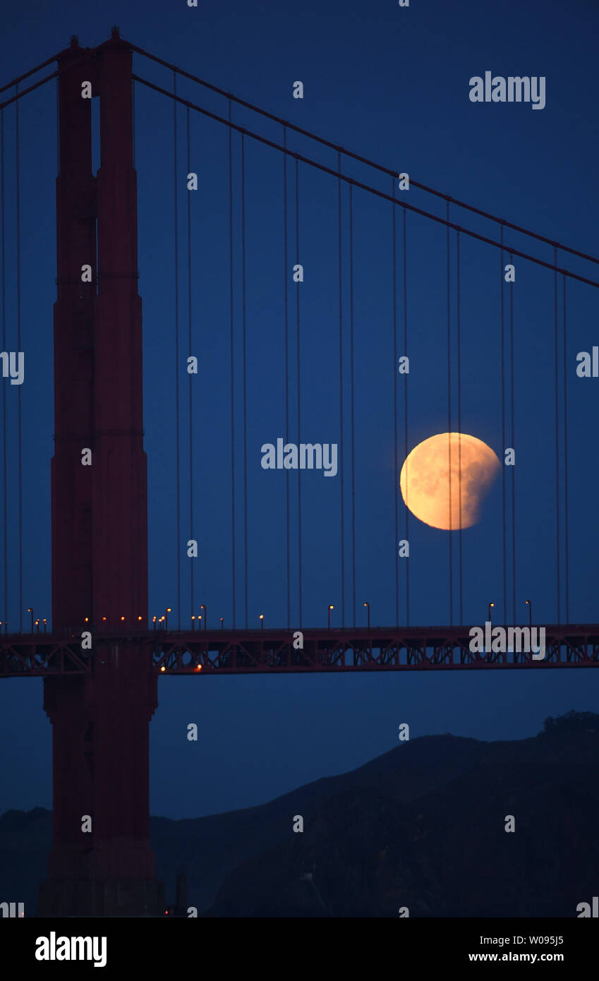 A super blue moon with the last vestiges of an eclipse sets behind the ...