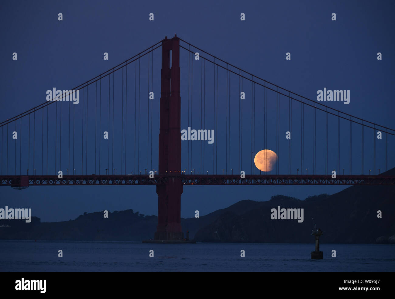 A super blue moon with the last vestiges of an eclipse sets behind the ...
