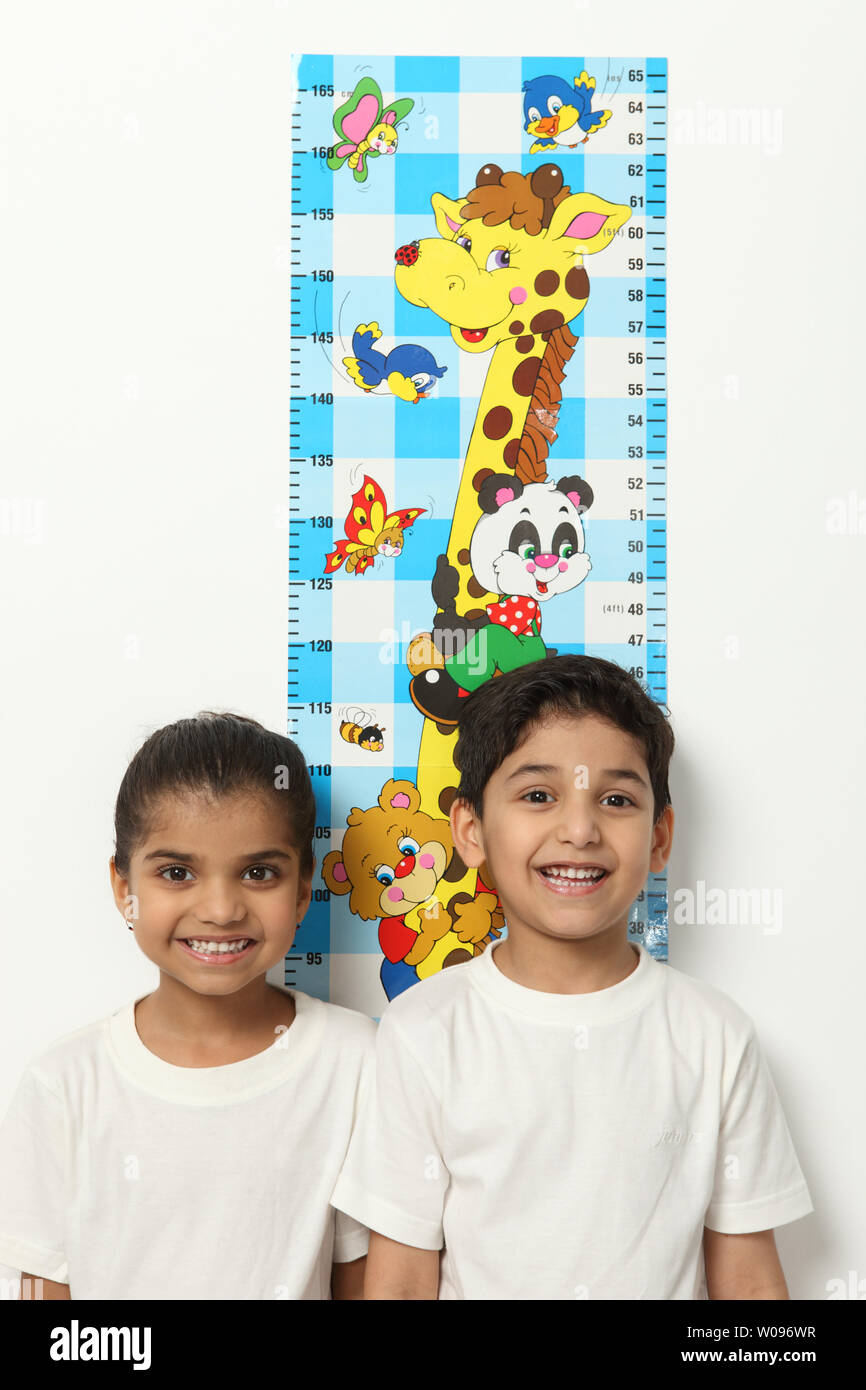 Portrait of two Indian children measuring their heights Stock Photo - Alamy