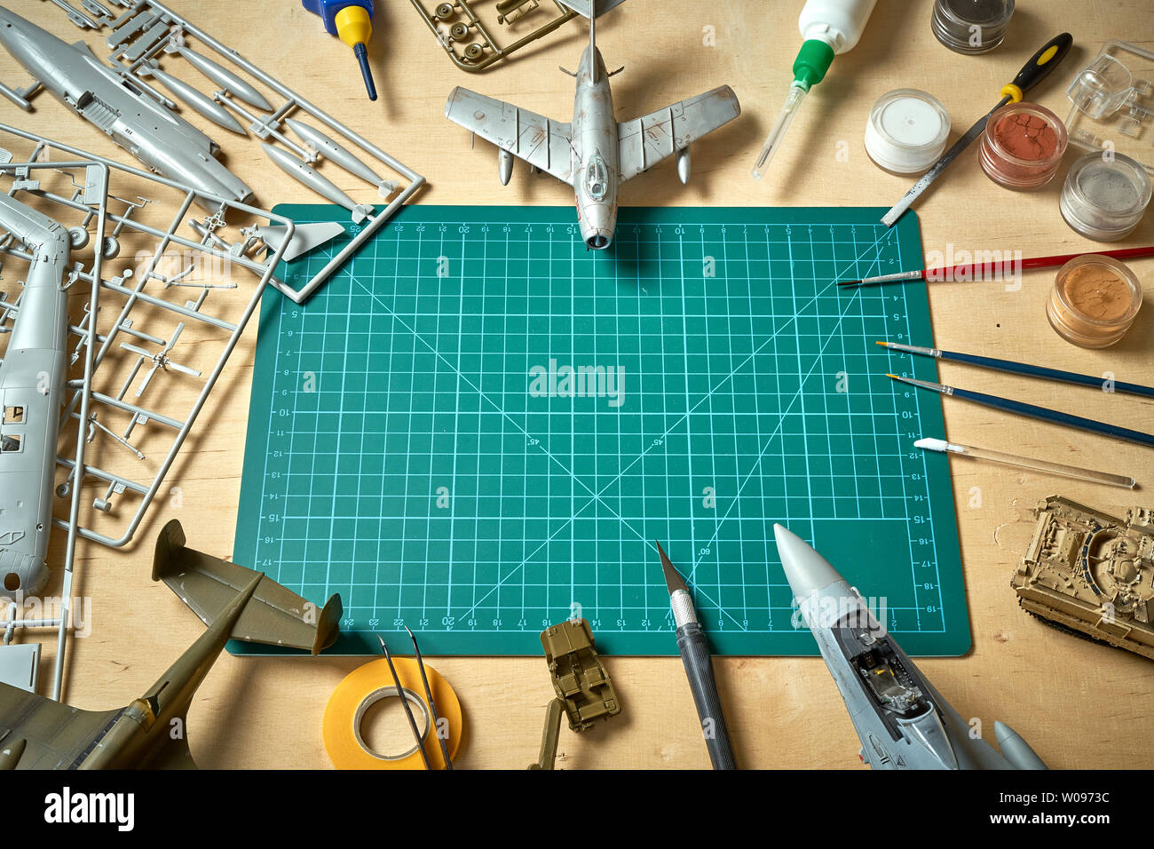 Top view on plastic model scale with accessories on green pad on wooden ...