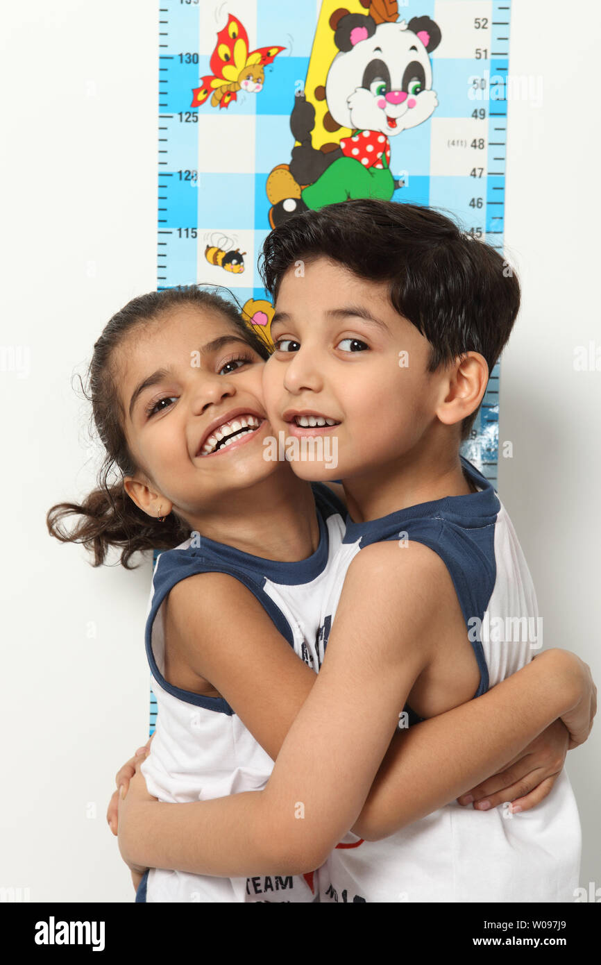 Two children playing in front of a height chart Stock Photo - Alamy