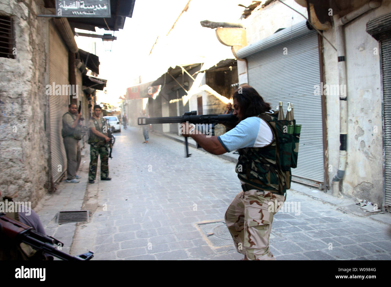 A member of the Free Syrian Army shoots his machine gun against Syrian ...