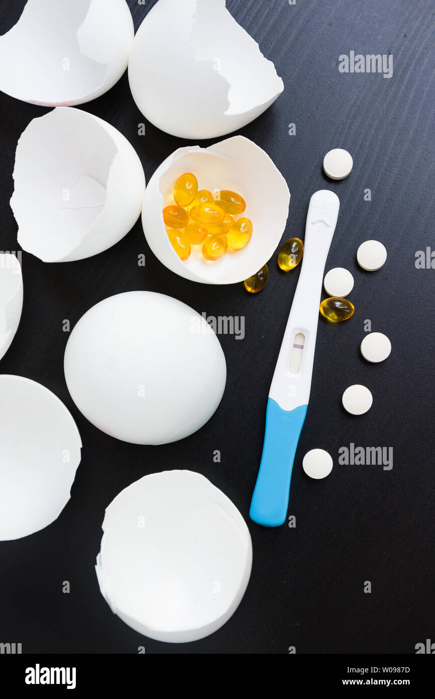 Infertility. Negative pregnancy test and eggshell on black background ...