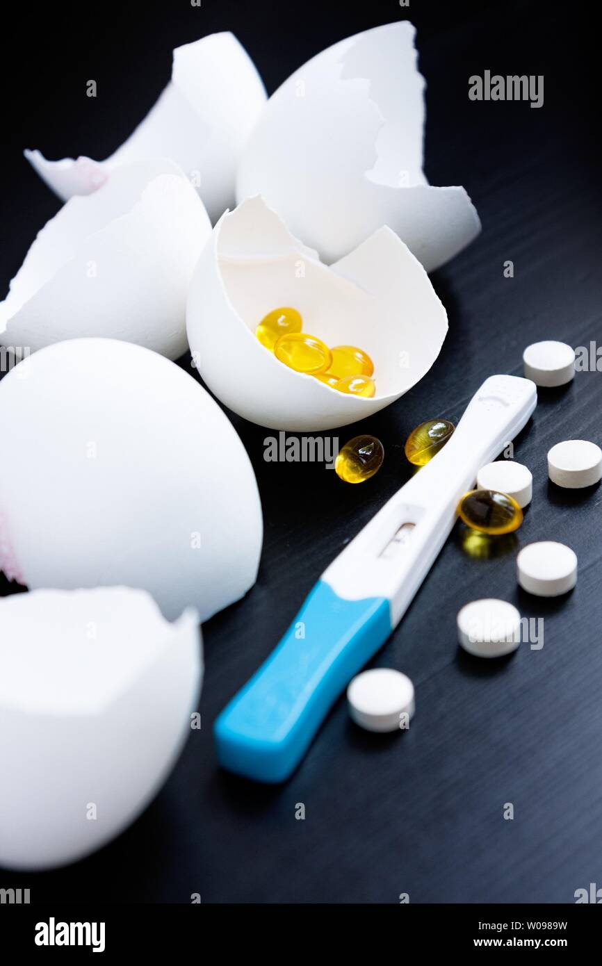Infertility. Negative pregnancy test and eggshell on black background ...