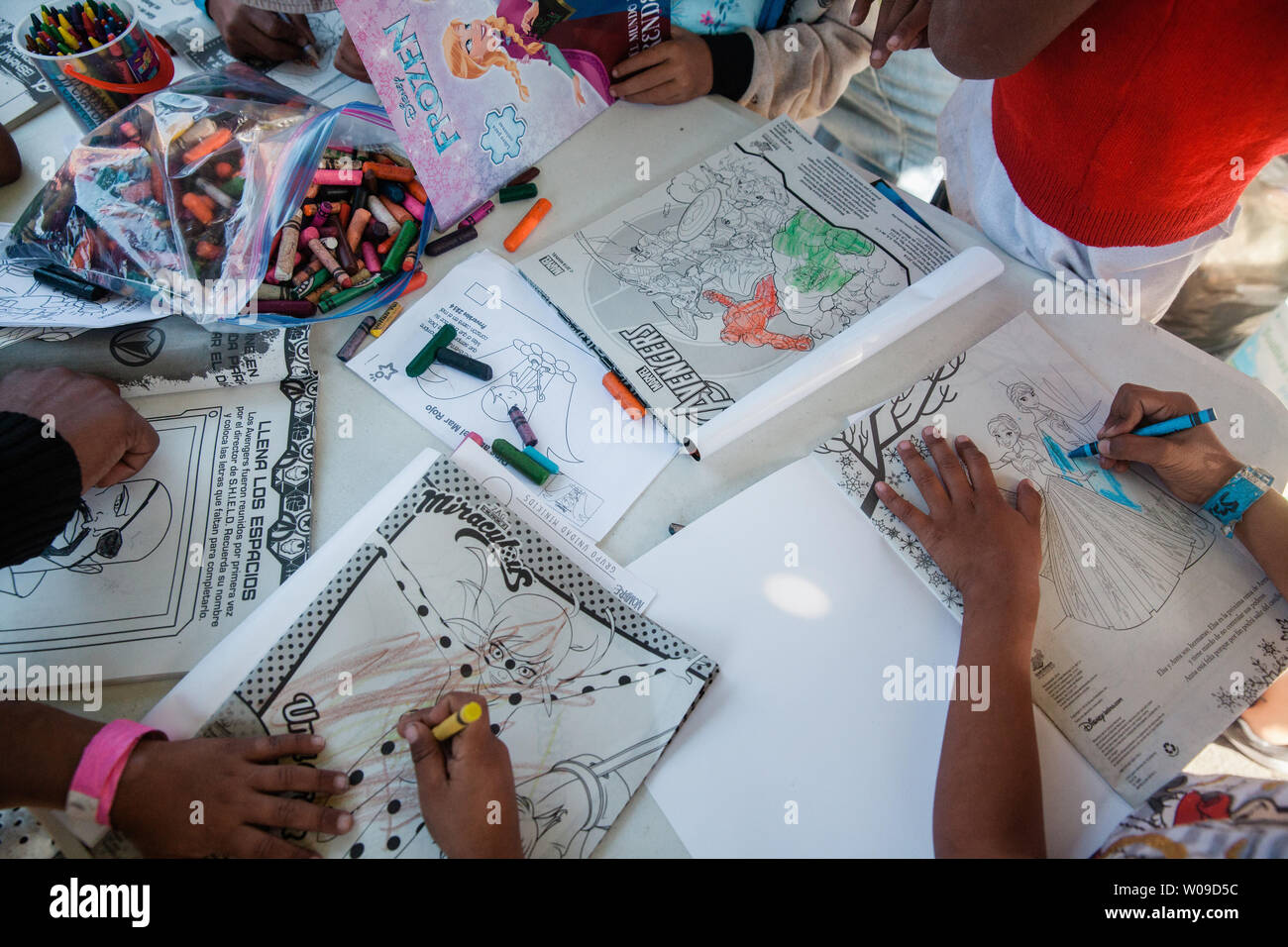 Children color at a table set up by a group of volunteers from Groupo ...