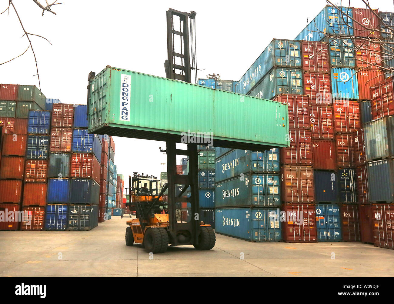 A shipping container lift crane delivers a container to a storage site ...