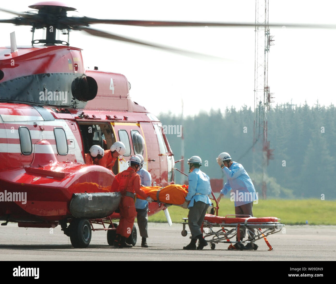 The emergency team members transport a patient from a helicopter of ...