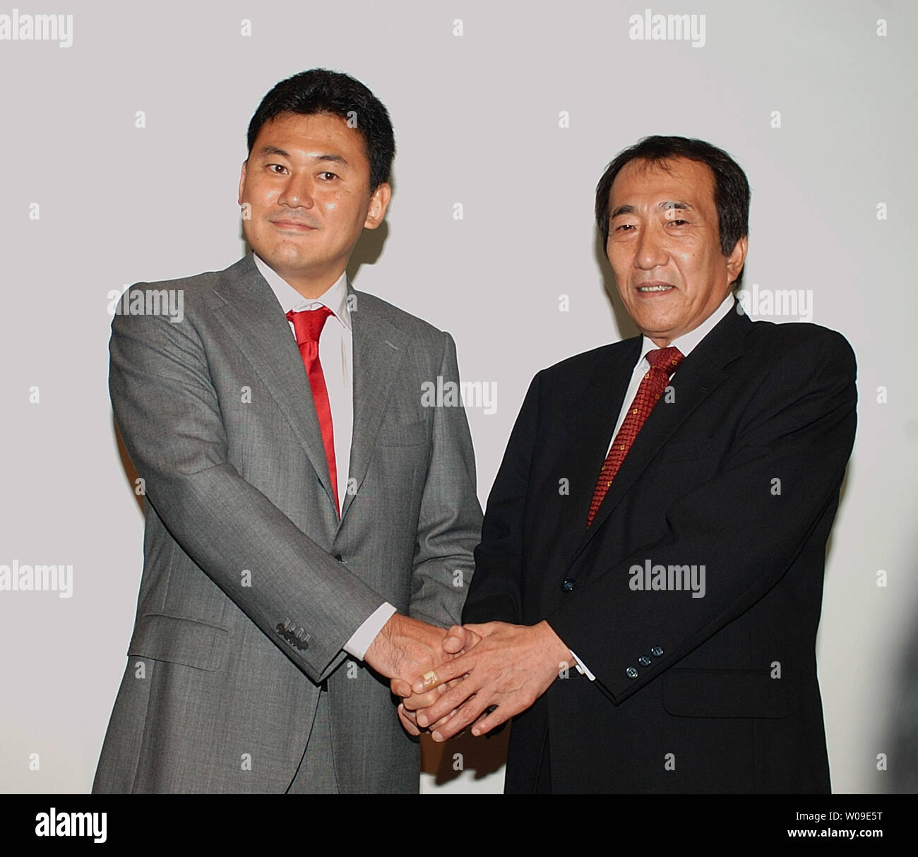 Masao Nakamura (R), President and CEO of NTT DoCoMo, shakes hands with ...
