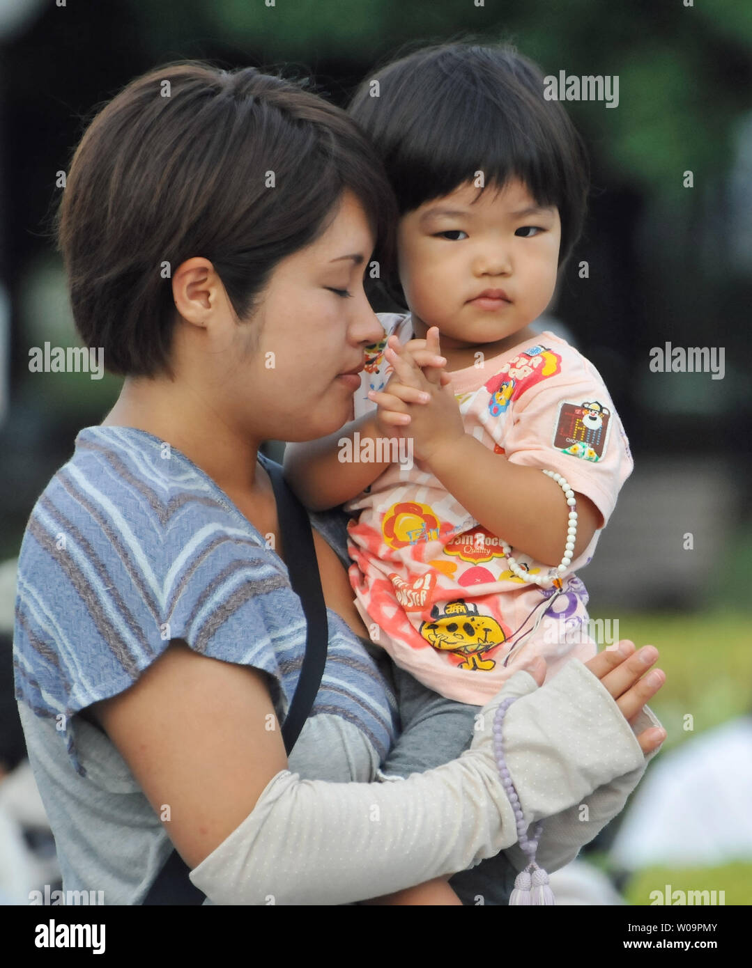 A woman and her child pray for the atomic bomb victims at Hiroshima ...