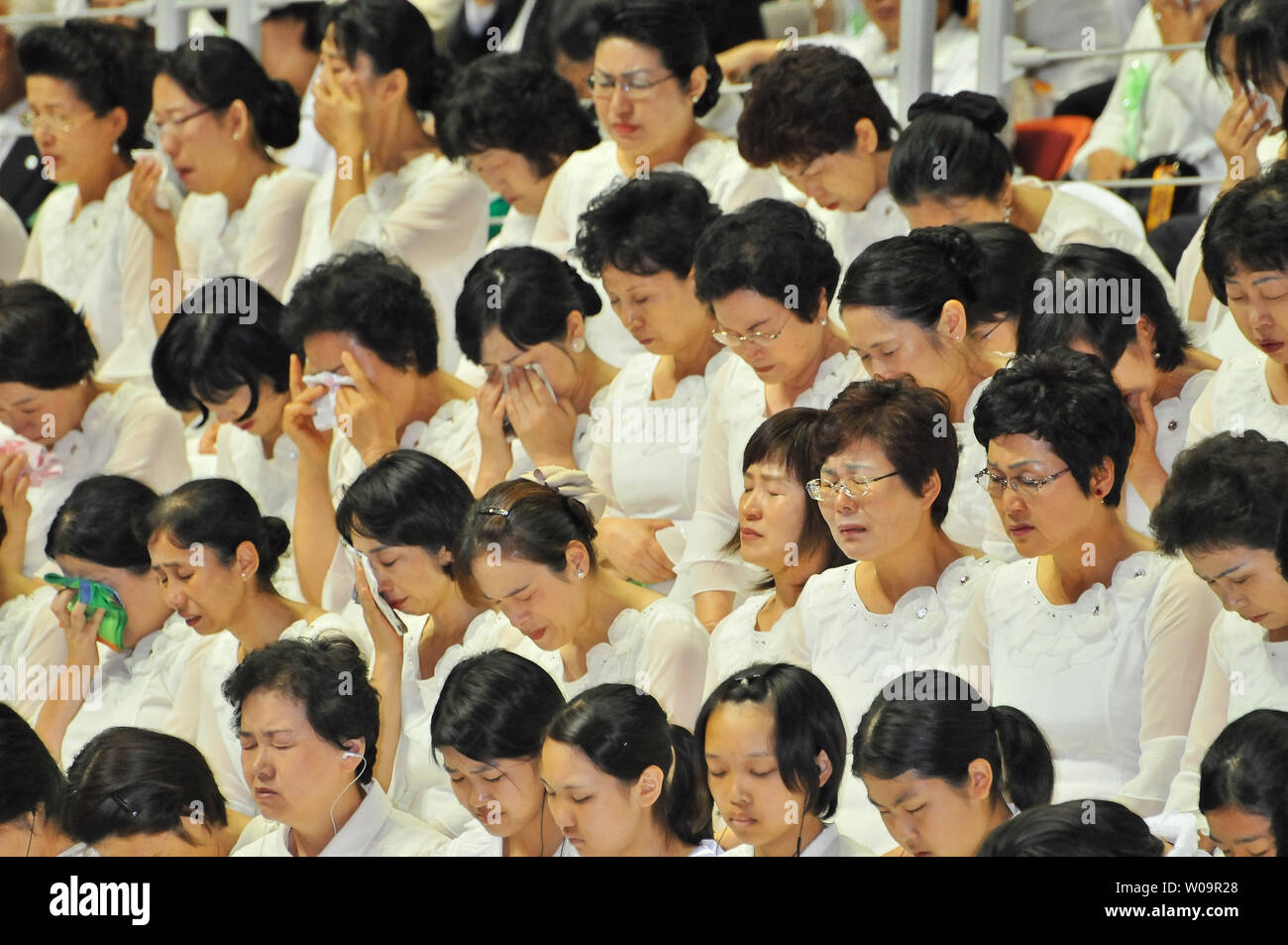 Members of the Unification Church weep during the funeral ceremony of ...