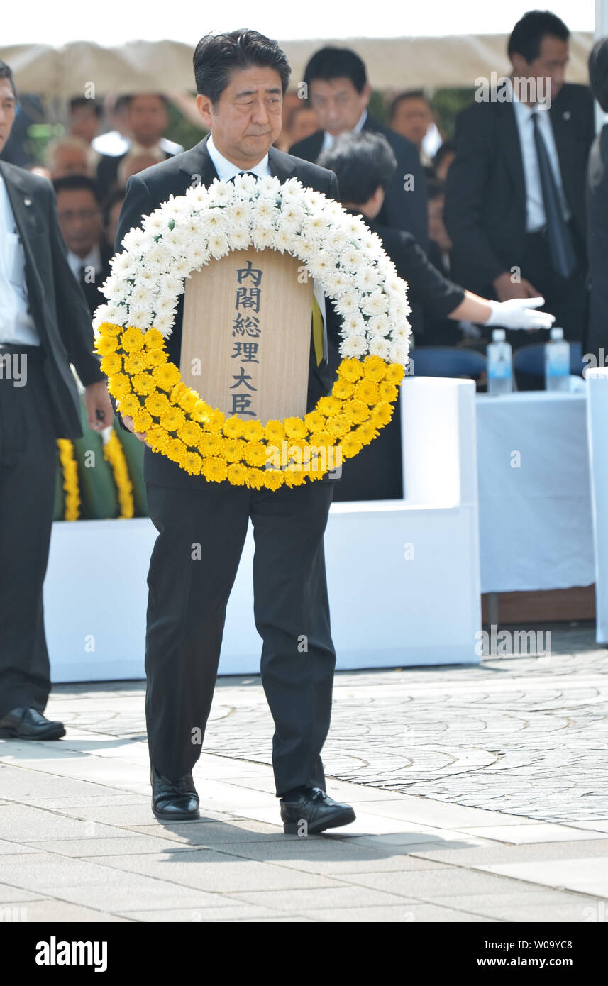 Japan's Prime Minister Shinzo Abe holds a wreath during a ceremony at ...