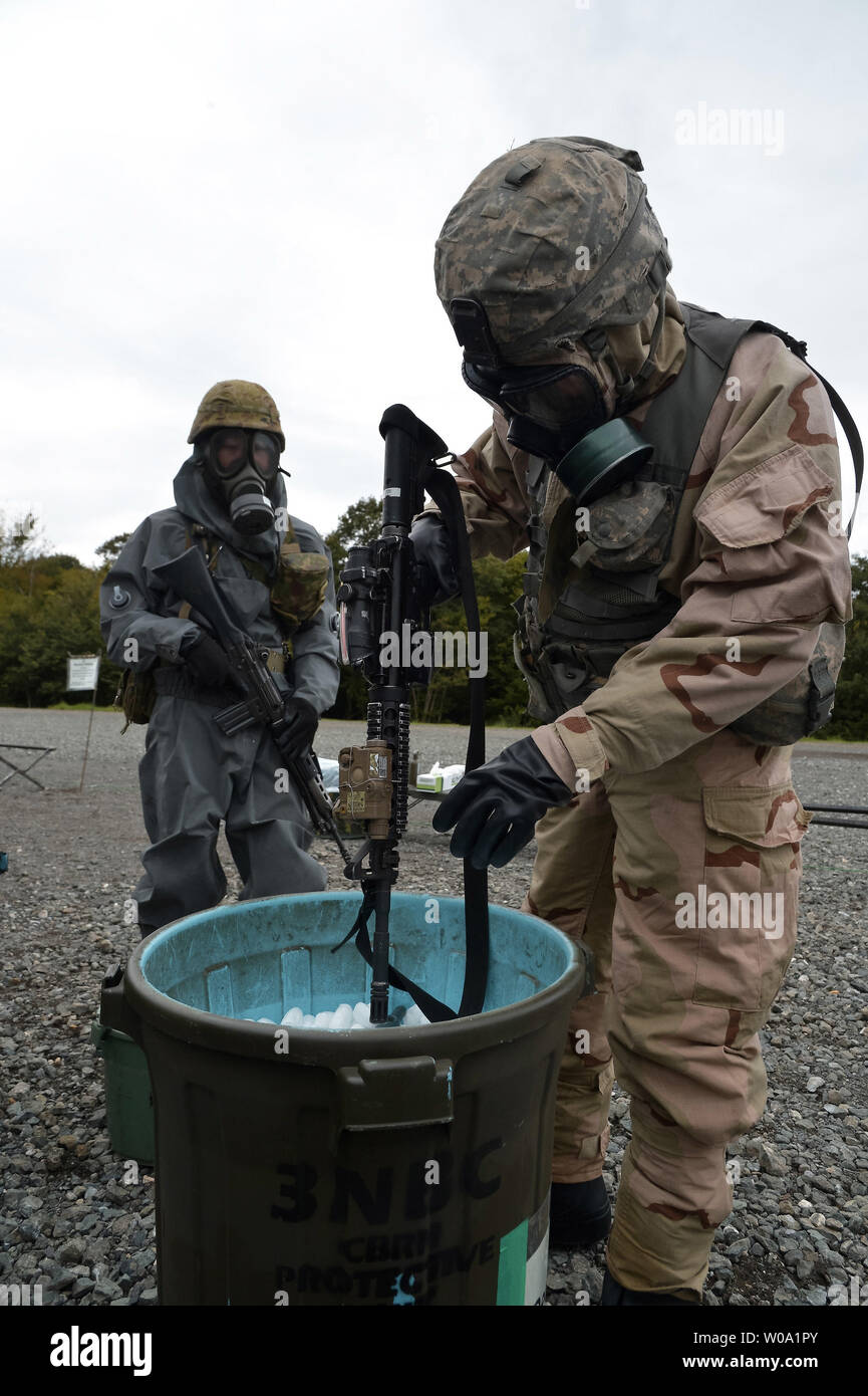 Member of U.S. Army conduct a decontamination for his M4 carbine during ...