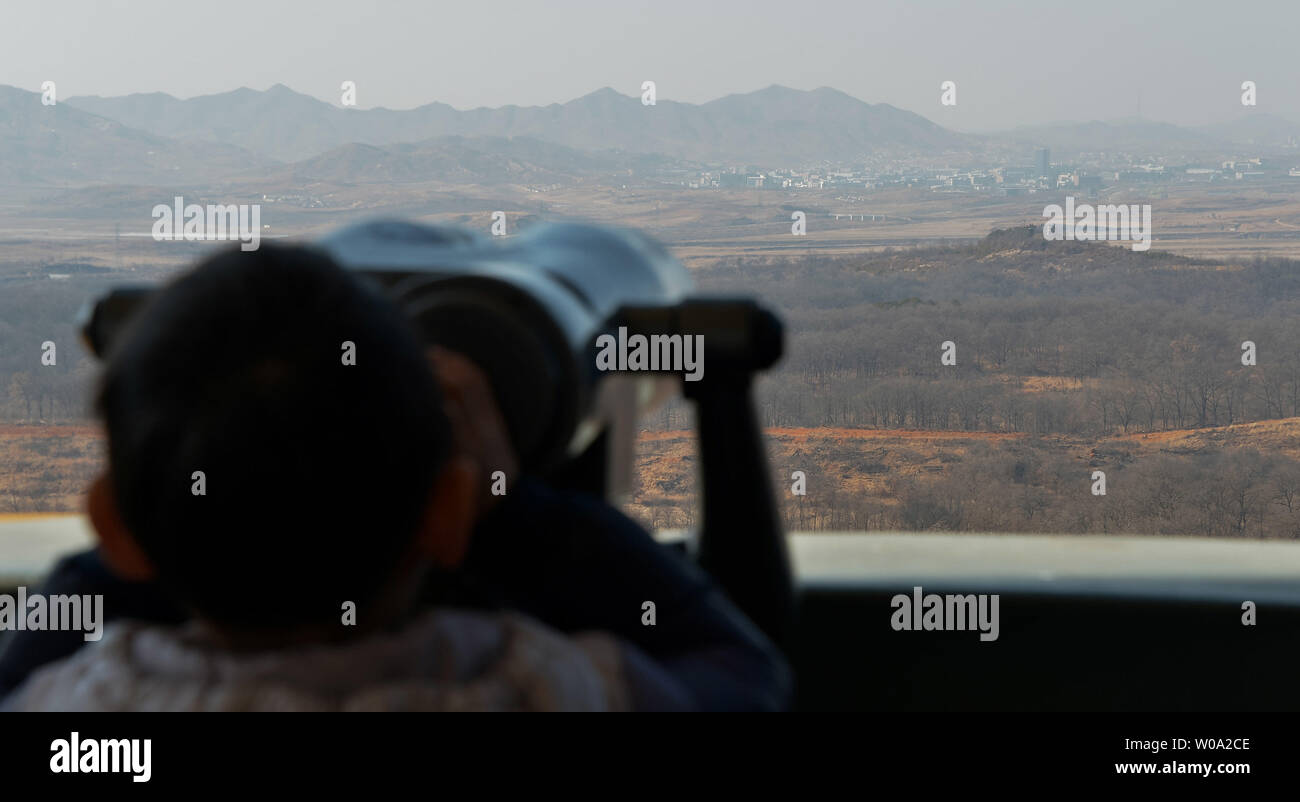 A tourist use binoculars to see North Korea at the Dorasan Observatory ...