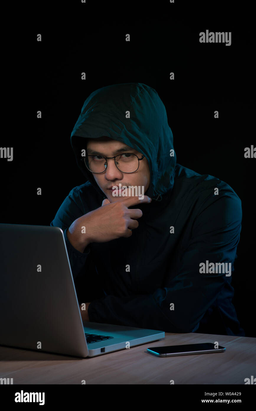 Computer hacker working in dark room Stock Photo - Alamy