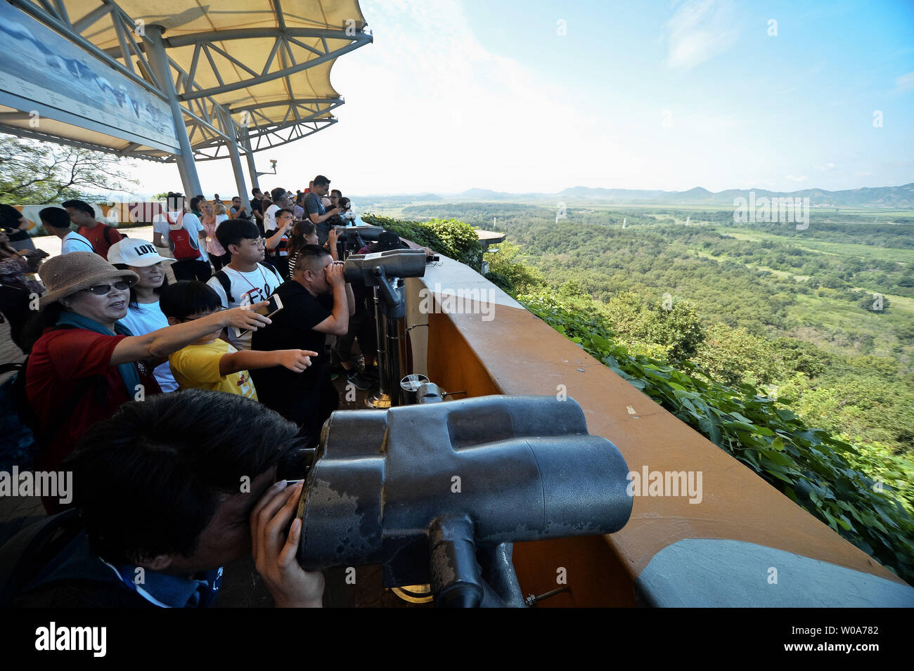 A tourist use binoculars to see North Korea at the Dorasan Observatory ...